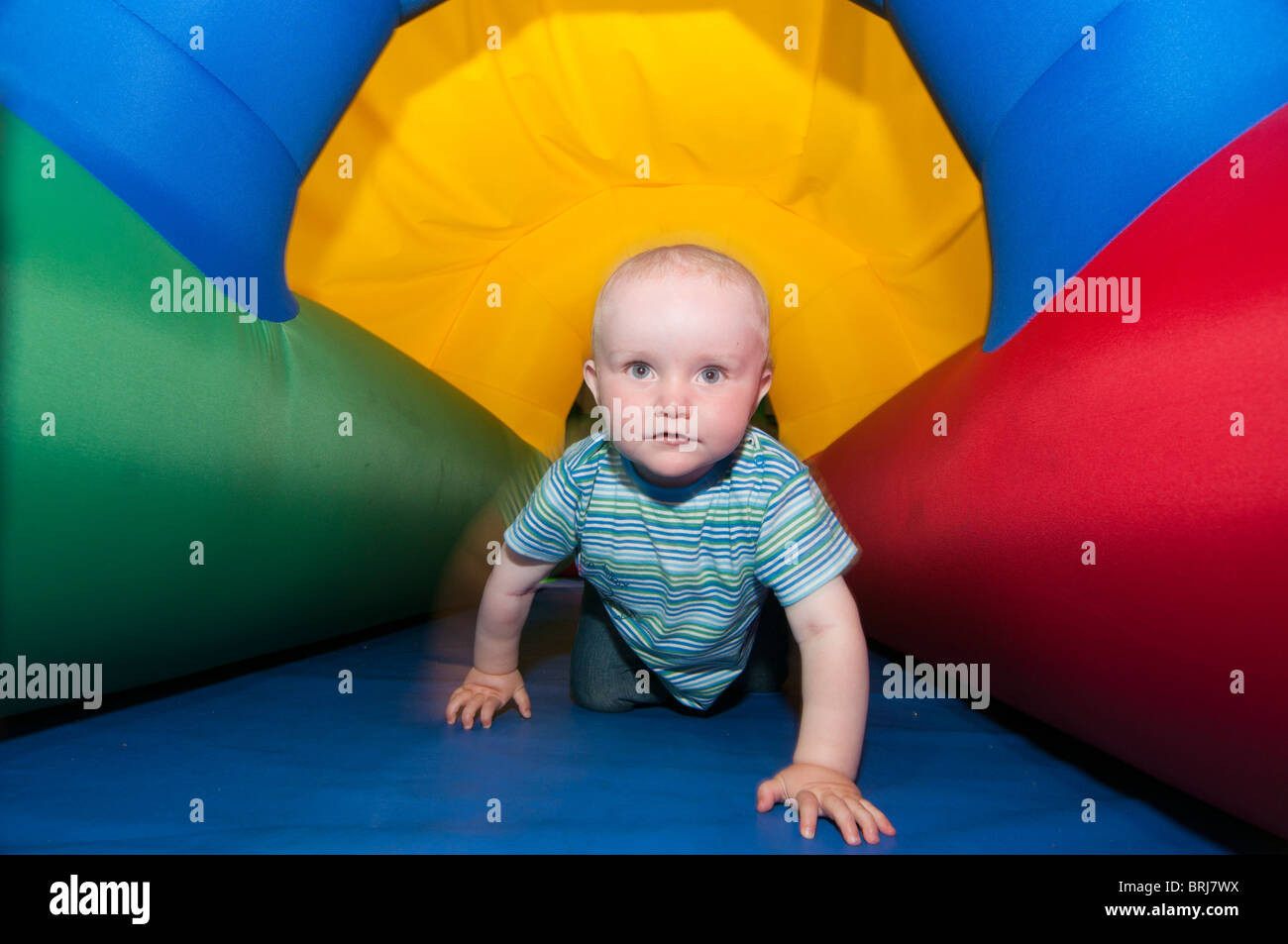 Baby crawling through bouncy castle Stock Photo - Alamy