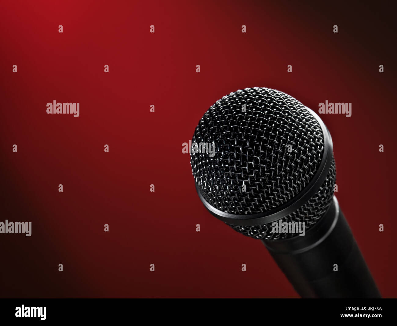 closeup of a microphone against red vignetted background, may be used ...