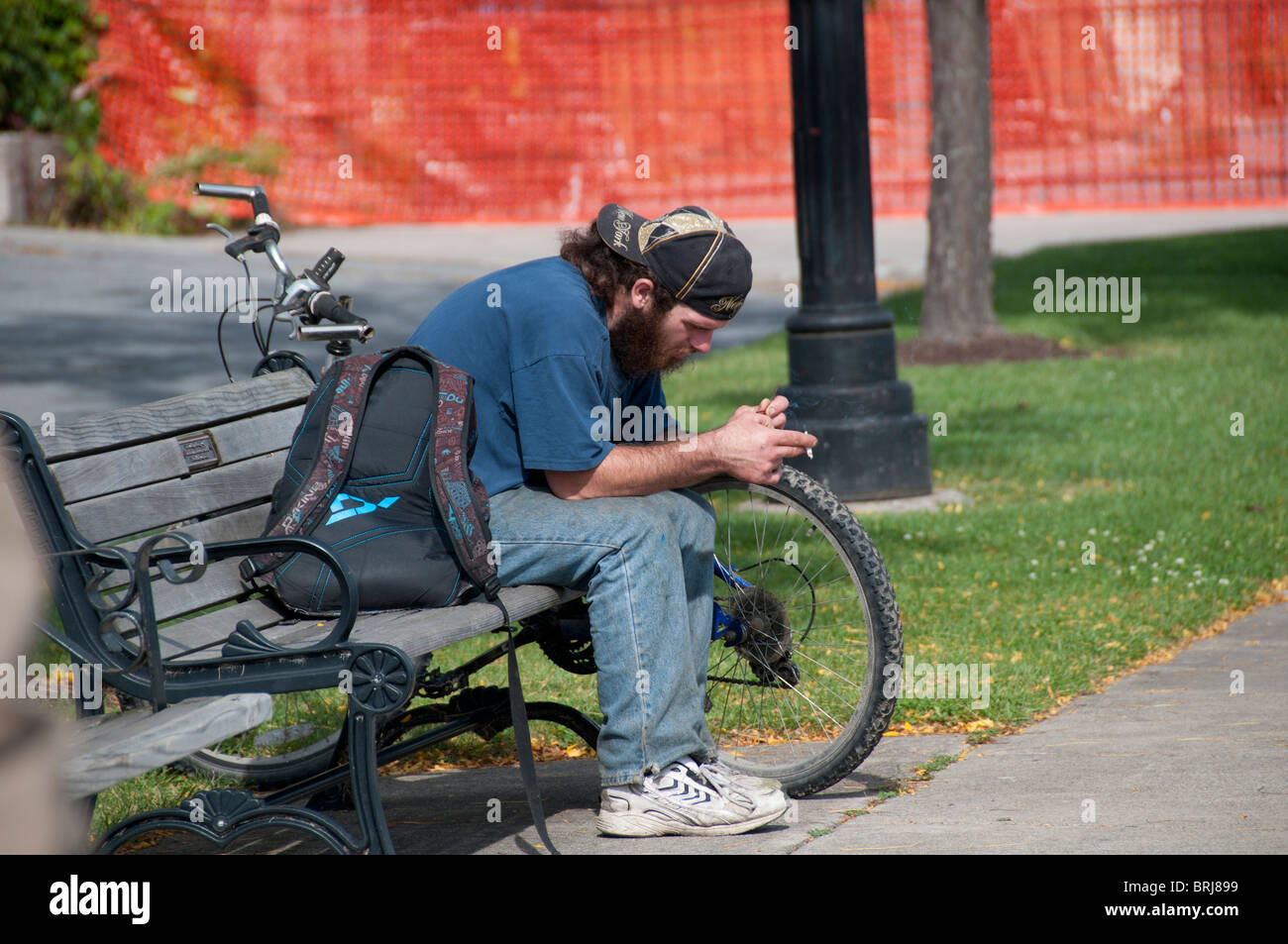 Young man on park bench Stock Photo - Alamy