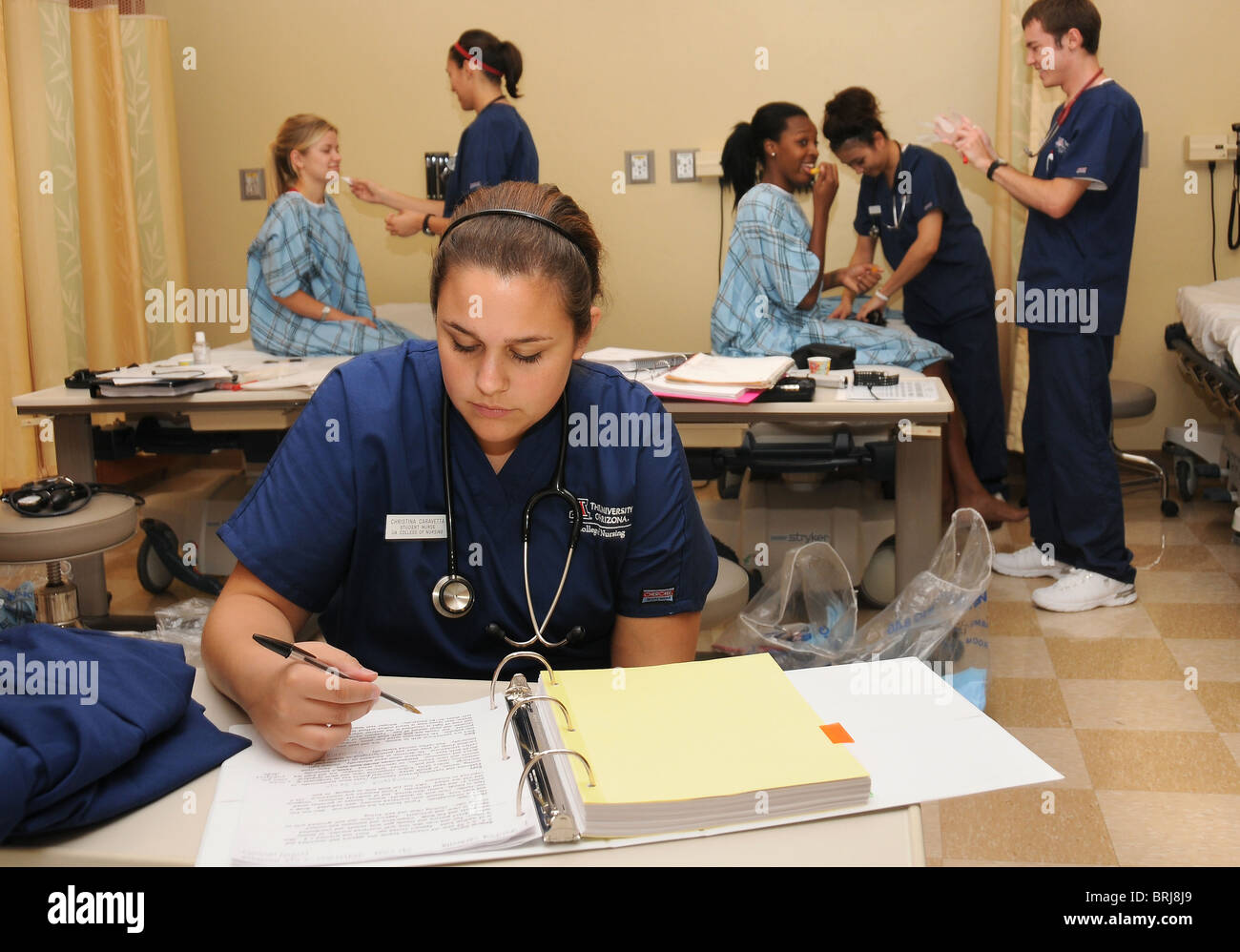 Nursing students conduct physical assessments on each other as part of ...