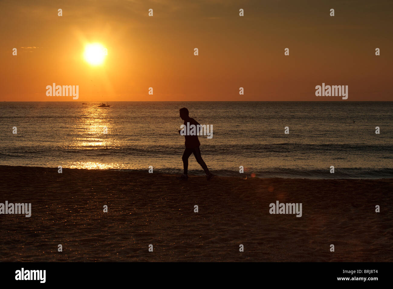 Person running in the beach at sunset Stock Photo - Alamy
