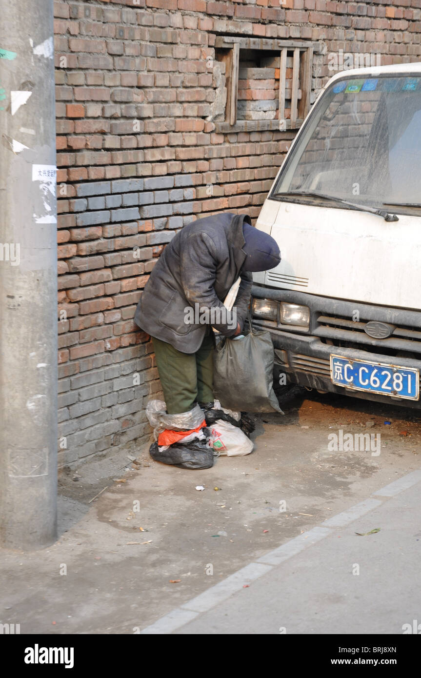 Poor man standing while sleeping in a Beijing hutong, China Stock Photo ...