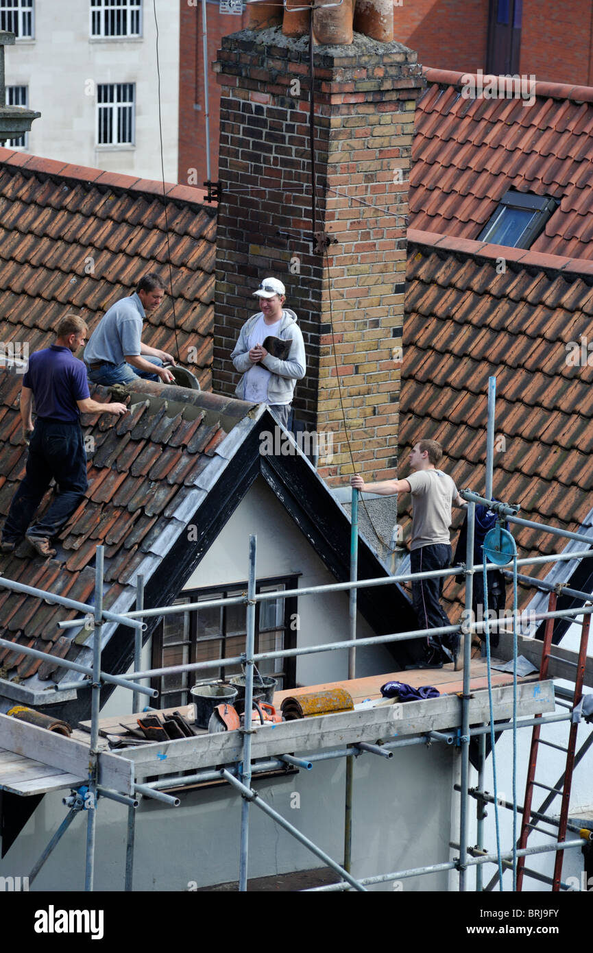 Builders replacing ridge tiles on roof refurbishment, UK Stock Photo ...