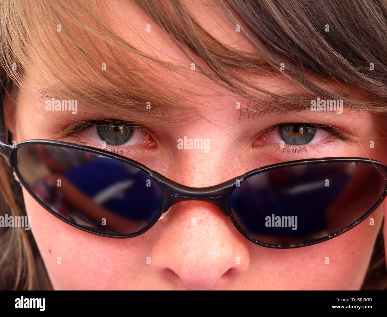 Young girl peering over sunglasses Stock Photo - Alamy