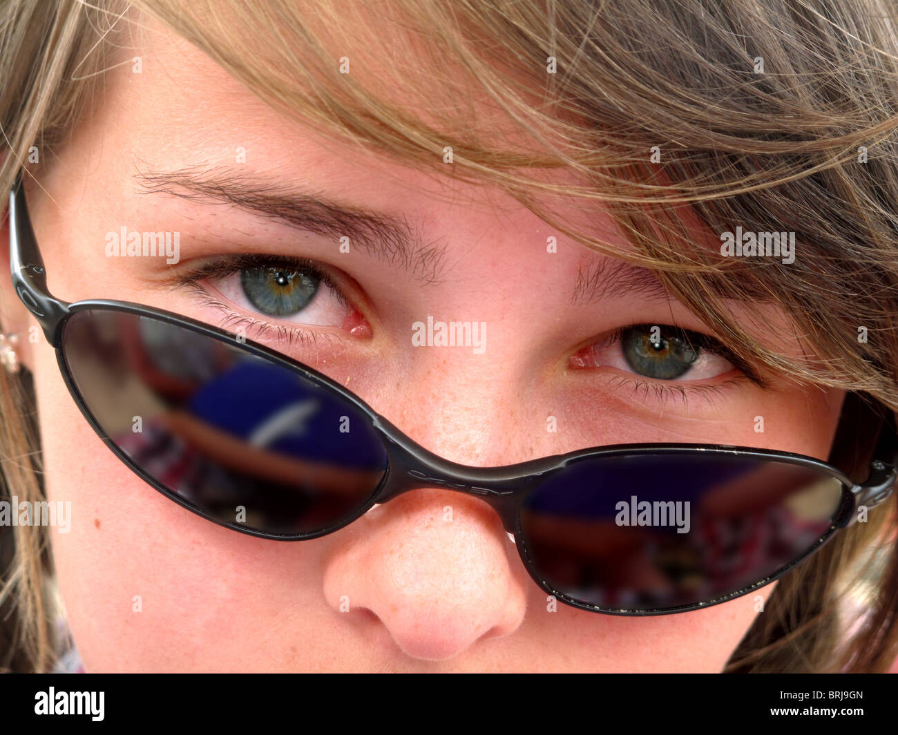 Young girl peering over sunglasses Stock Photo - Alamy