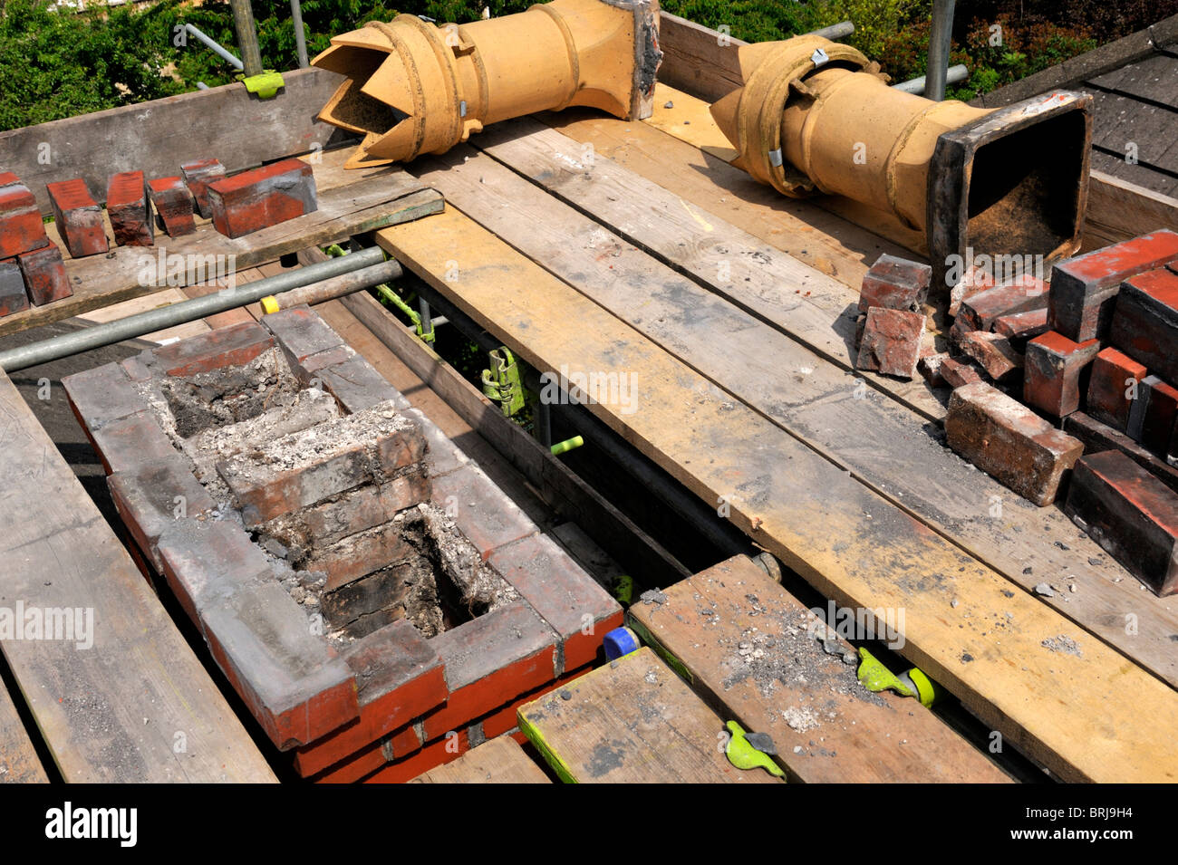 Looking down on top of open brick domestic chimney stack being repaired ...