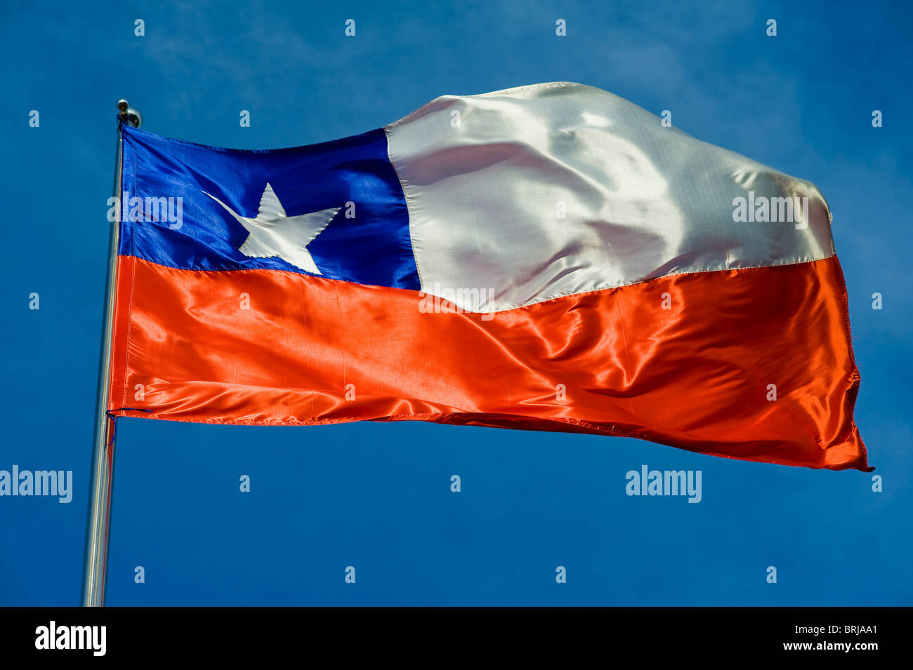 chilean flag on a pole against blue sky Stock Photo - Alamy