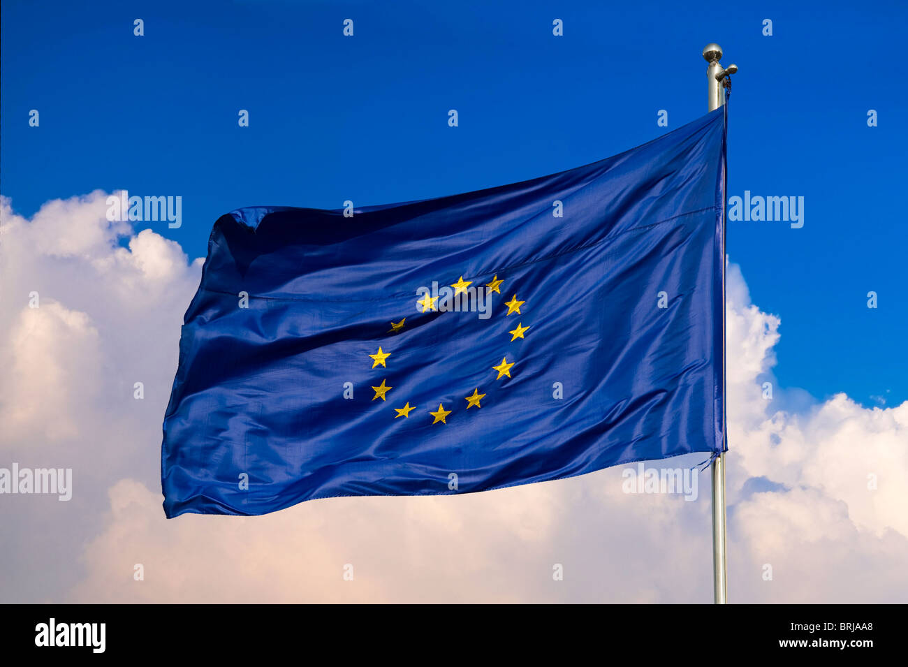 european union flag on a pole against blue, cloudy sky Stock Photo - Alamy