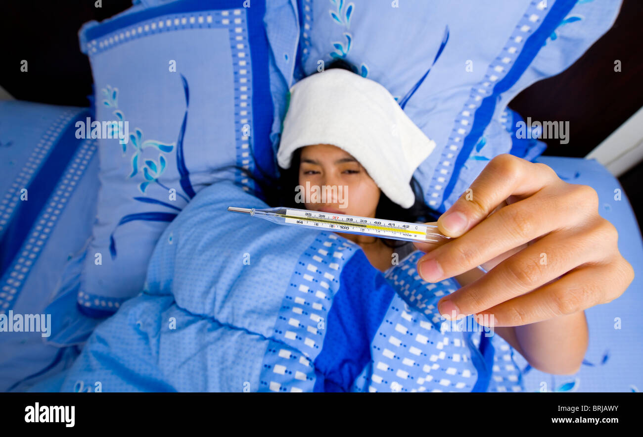 beautiful young woman having over 39?C /102?F fever. focus on ...