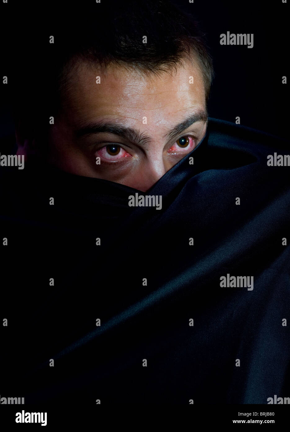 creepy caucasian man hiding behind black silk Stock Photo - Alamy