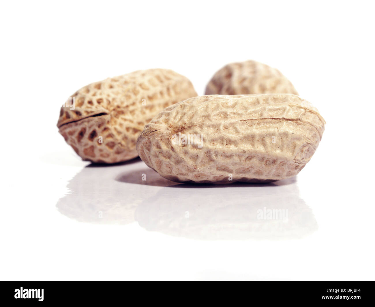 Three unshelled peanuts, isolated on white with reflection Stock Photo ...