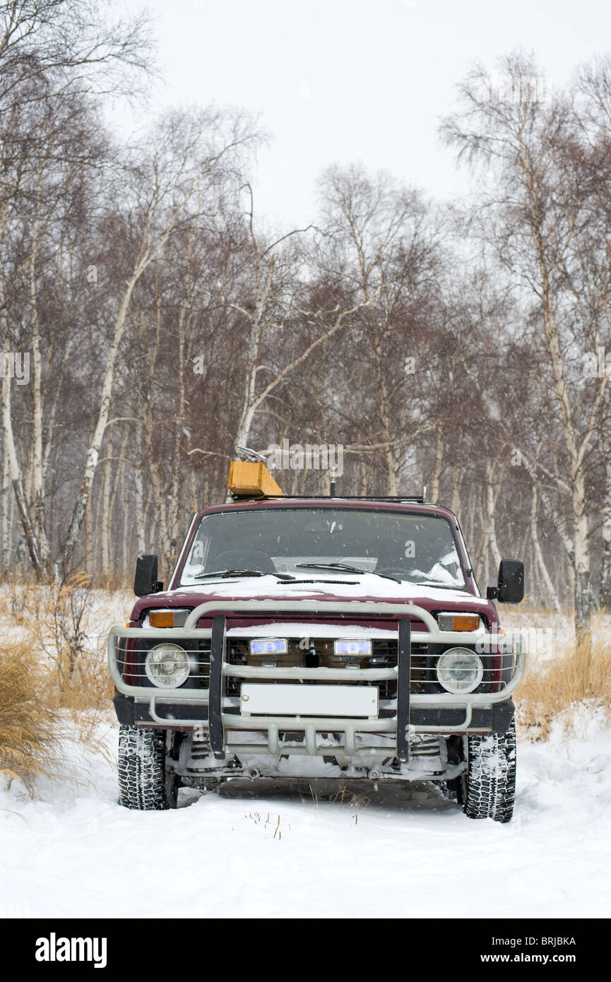 russian off-road four-wheel drive vehicle in winter birch forest while ...