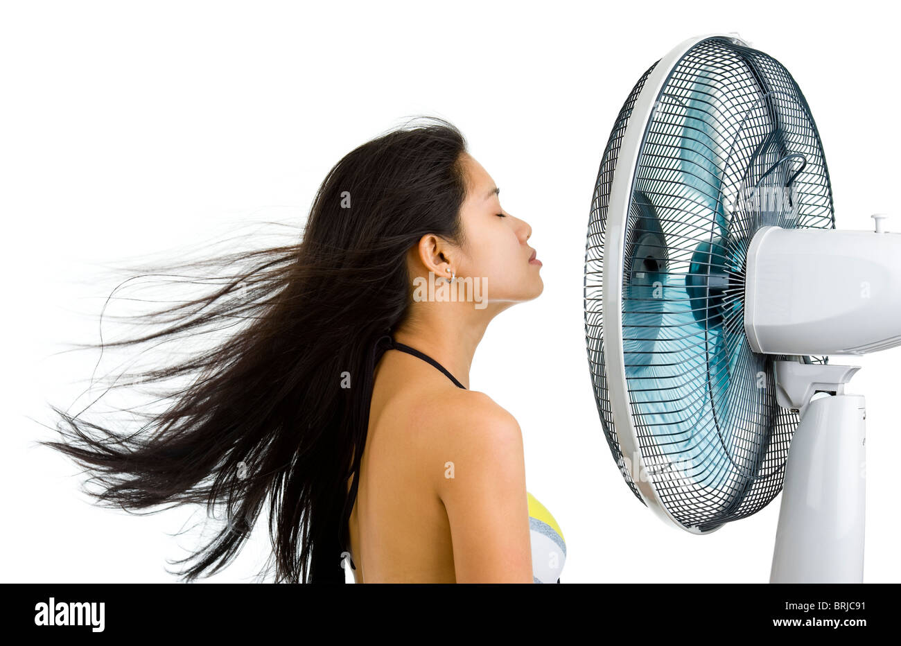 pretty woman enjoying fan blowing from front right side, isolated on ...