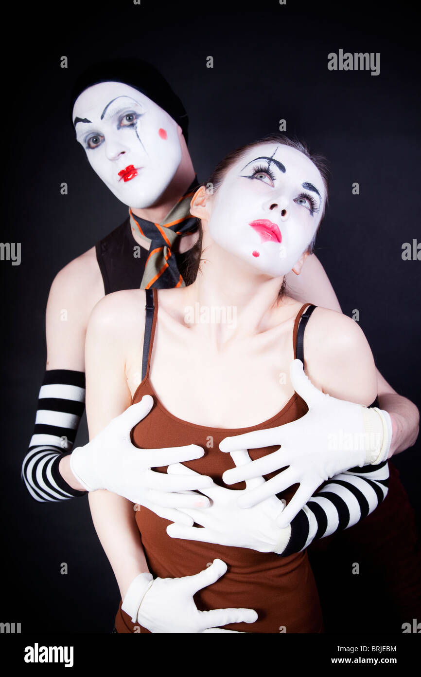 Couple embracing mimes on a black background Stock Photo - Alamy