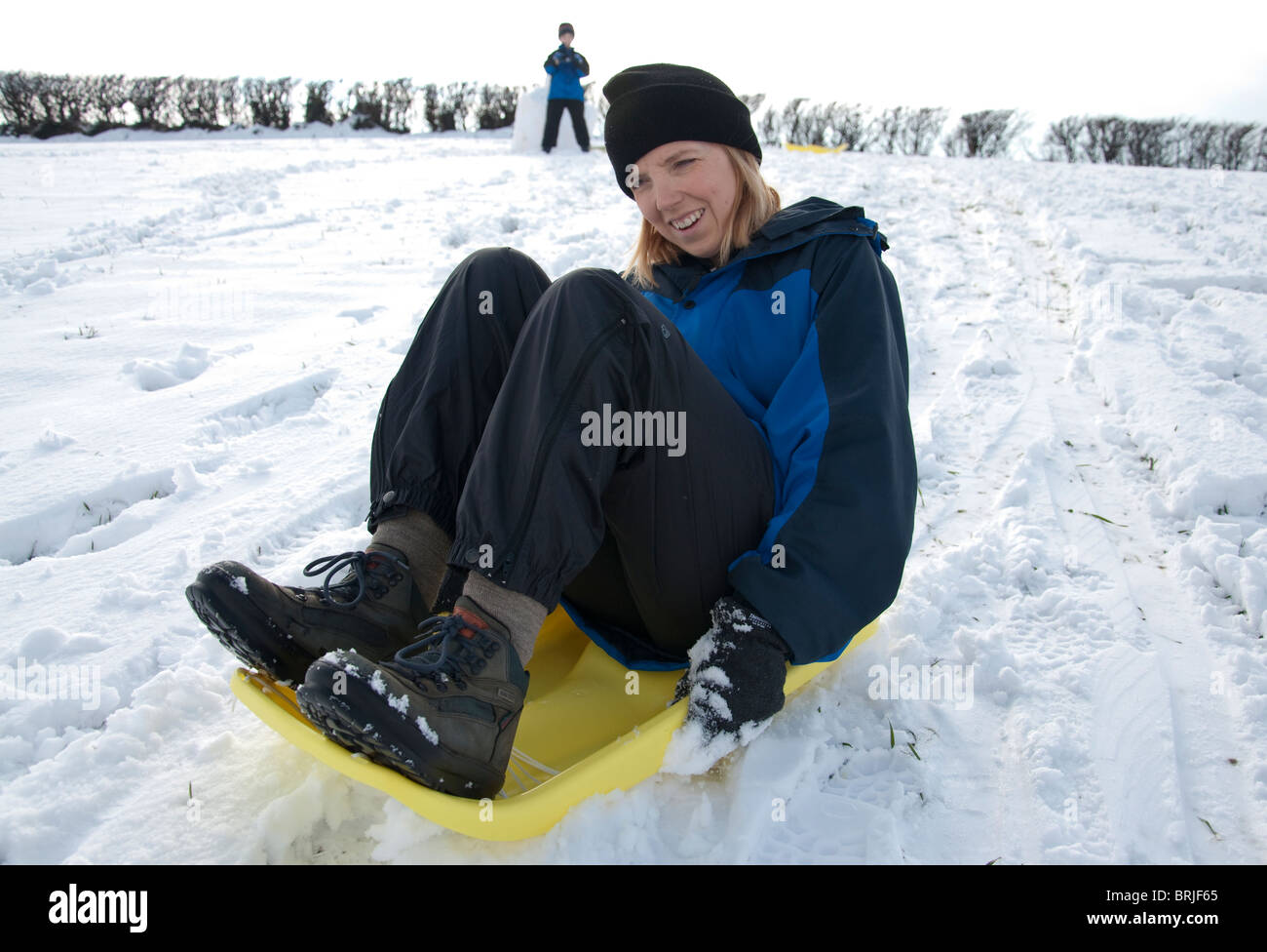 Young women on sledge in snow Stock Photo - Alamy