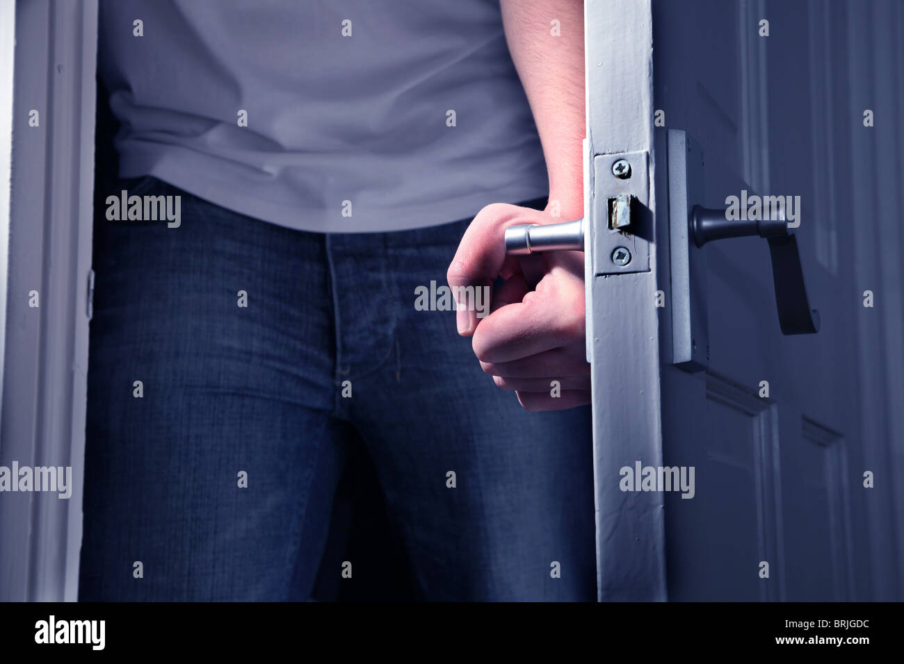 Male hand turning a door handle entering a dark room Stock Photo - Alamy