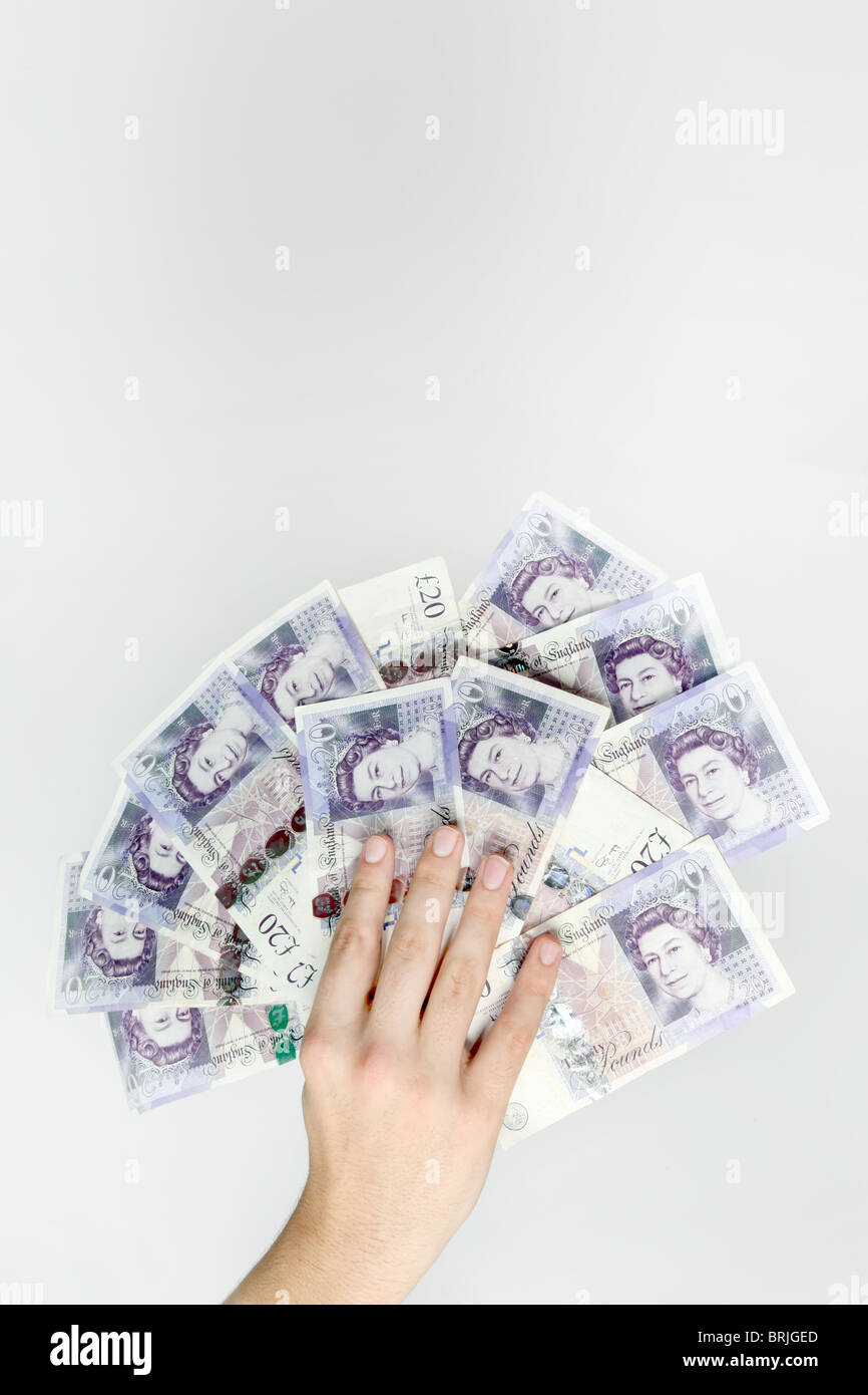 Male Caucasian hand holding a bunch of British £20 notes Stock Photo ...