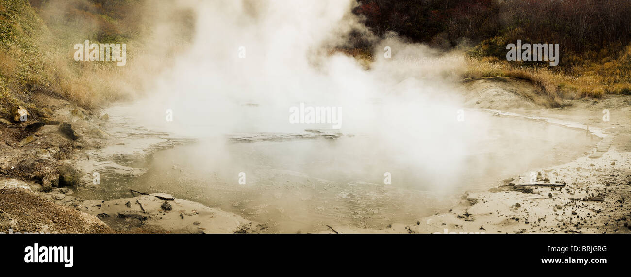 Panoramic of volcanic mud pool with steam rising up Stock Photo - Alamy