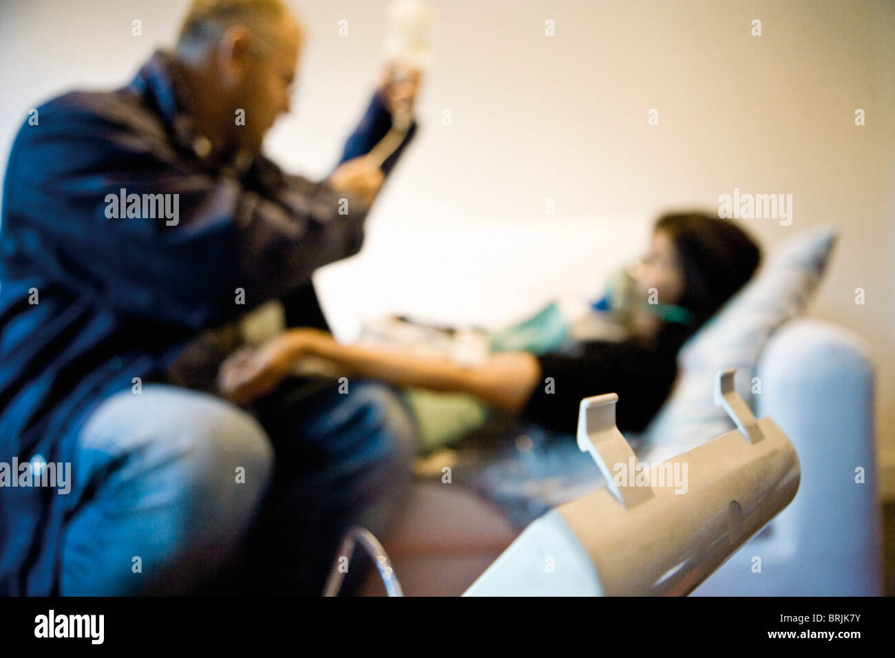 Doctor treating patient in home Stock Photo - Alamy