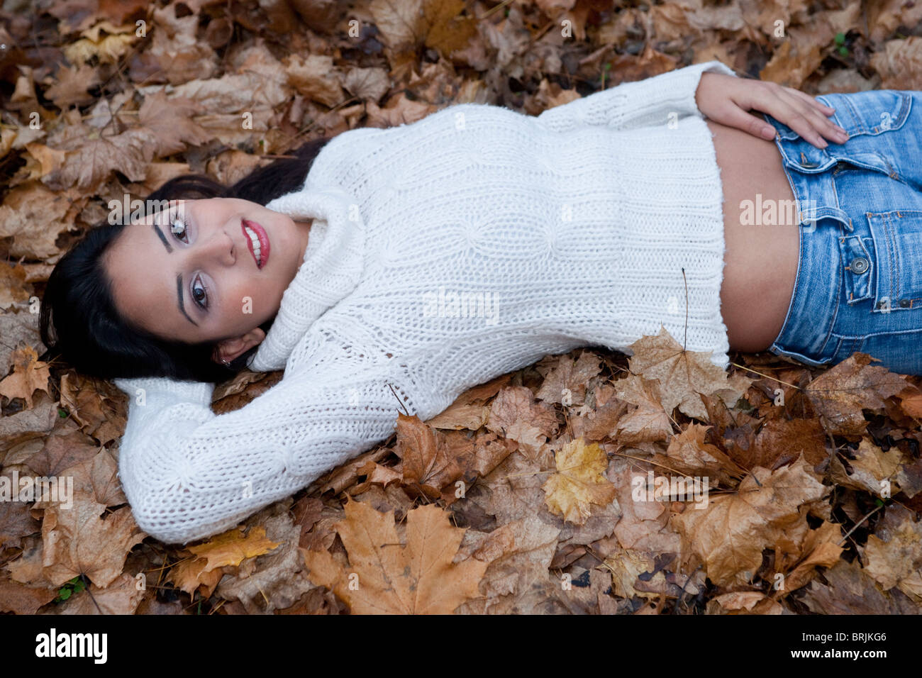 Woman Lying Down in Autumn Leaves Stock Photo - Alamy