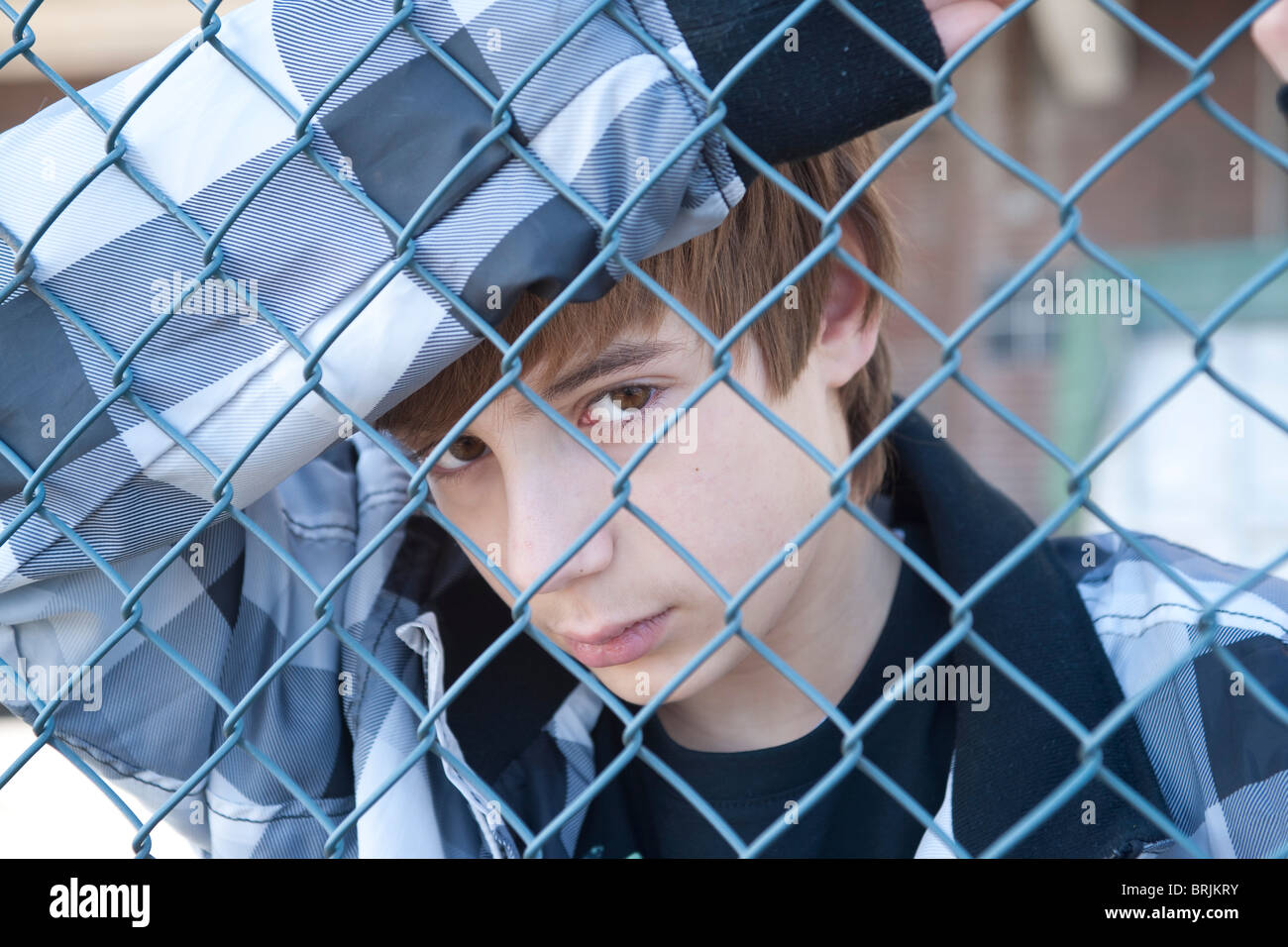 Teenage Boy Behind Fence Stock Photo - Alamy