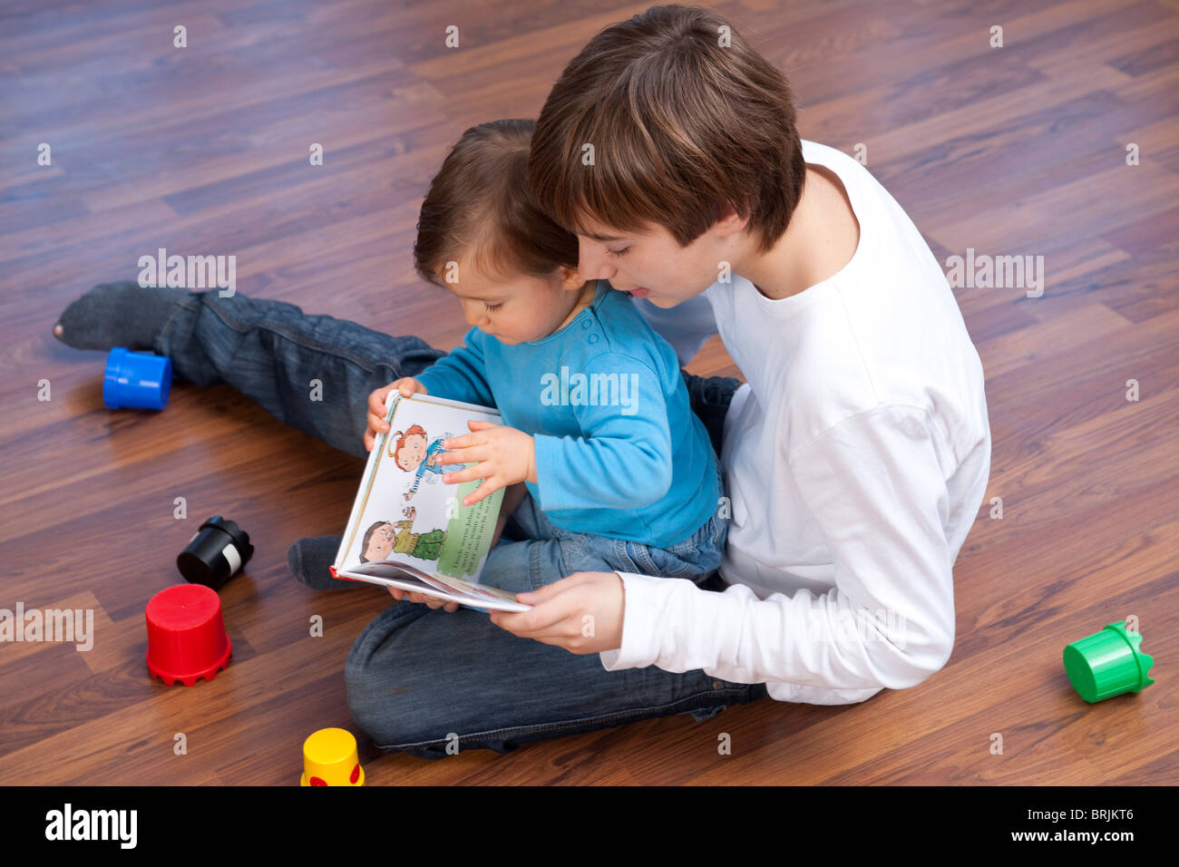 Teenage Boy Reading to Younger Brother Stock Photo - Alamy