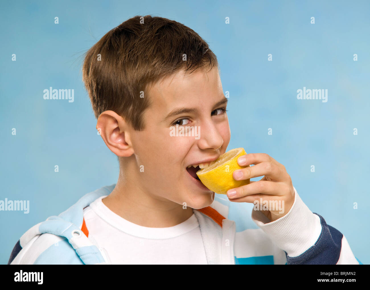 Boy Eating a Lemon Stock Photo - Alamy