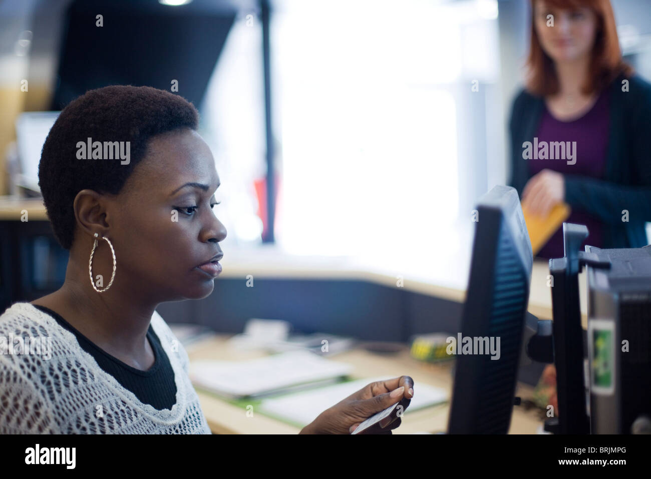 Female receptionist looking up information on computer Stock Photo - Alamy