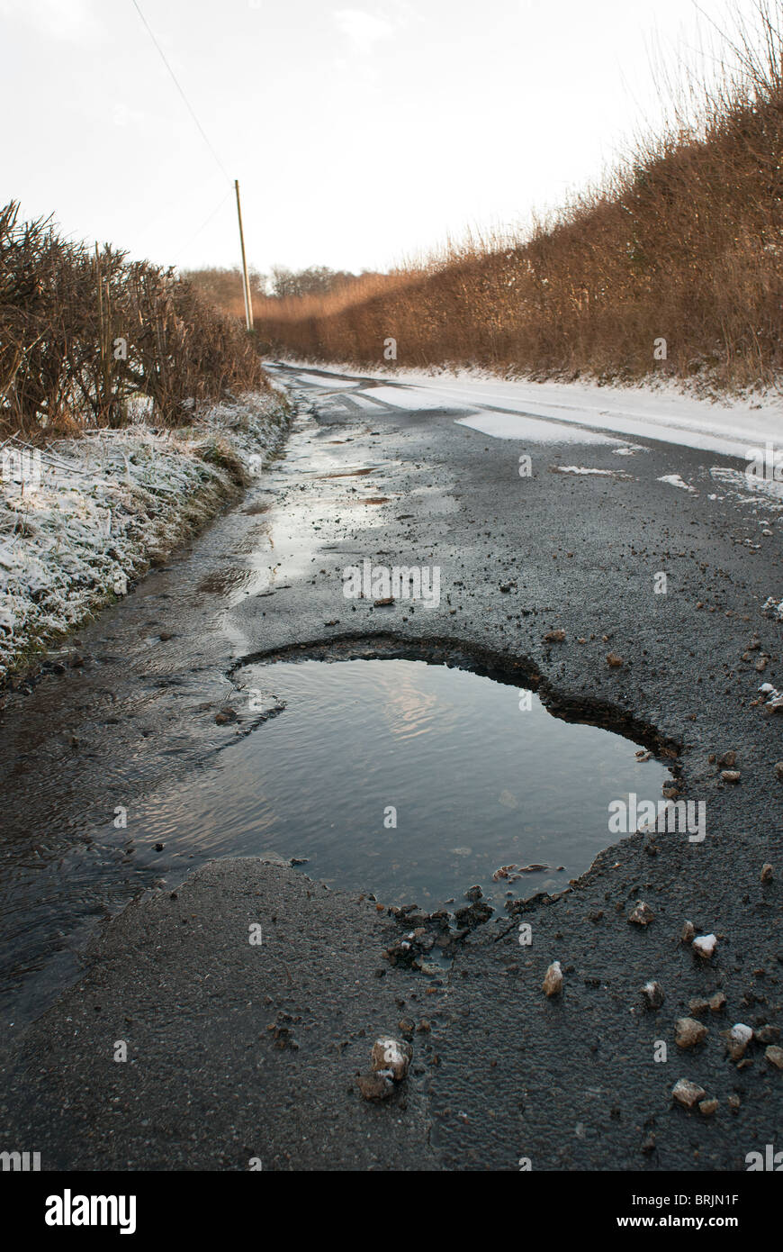Potholes in a country road caused by snow and freezing weather Stock ...