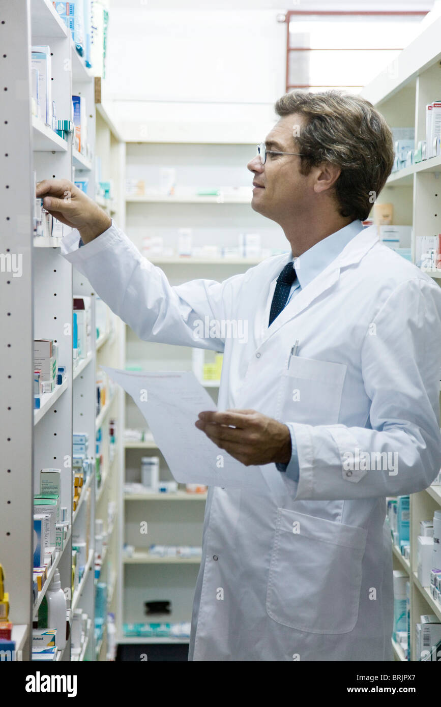 Pharmacist checking shelf for medication Stock Photo - Alamy