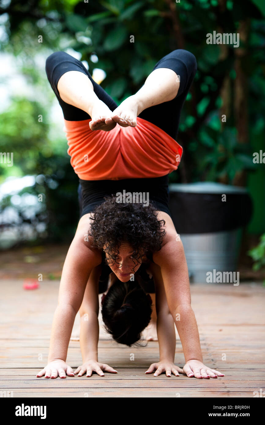 Two female yogis posing in a partner handstand outside Stock Photo - Alamy