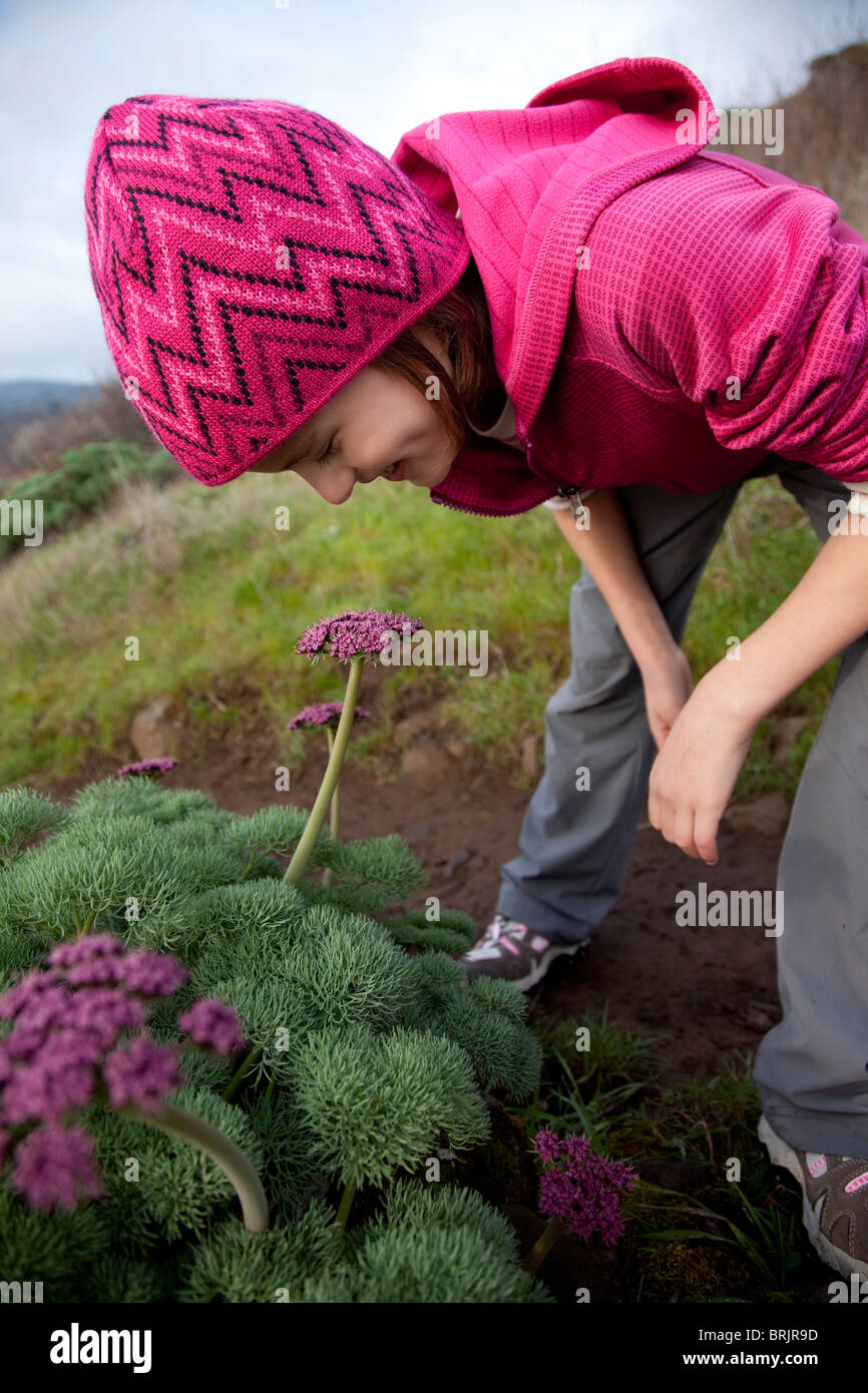 A young girl dressed in pink smells the spring flowers, while out ...
