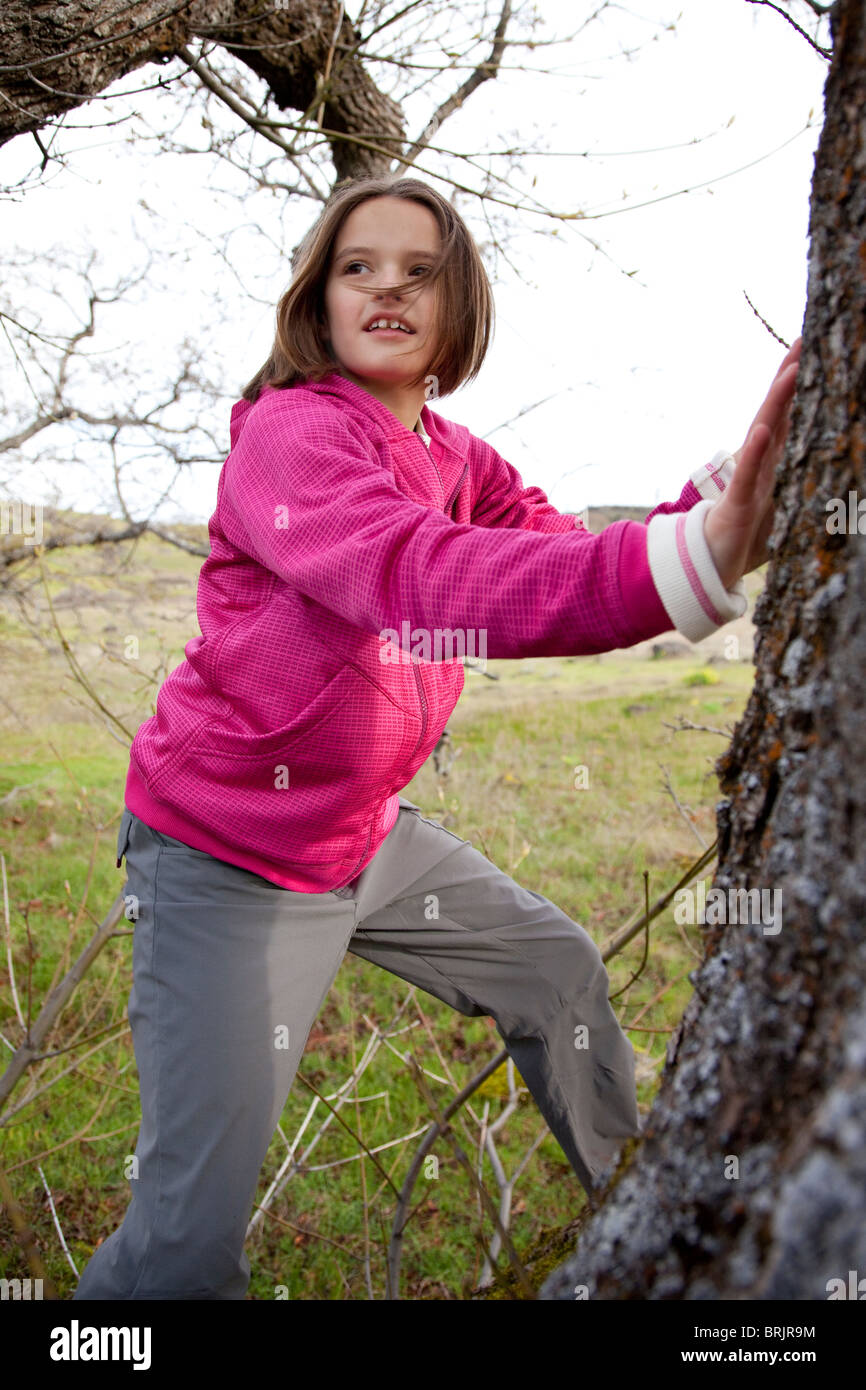 A young girl dressed in pink standing in a tree Stock Photo - Alamy