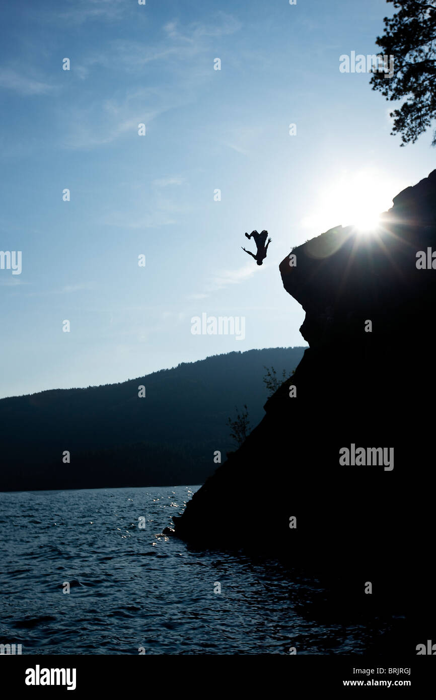 A young man flips off a rock outcropping in Idaho Stock Photo - Alamy