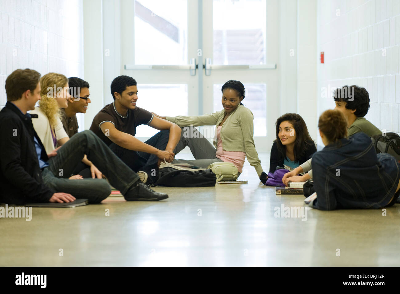 Students hanging out together, sitting on school corridor floor Stock ...
