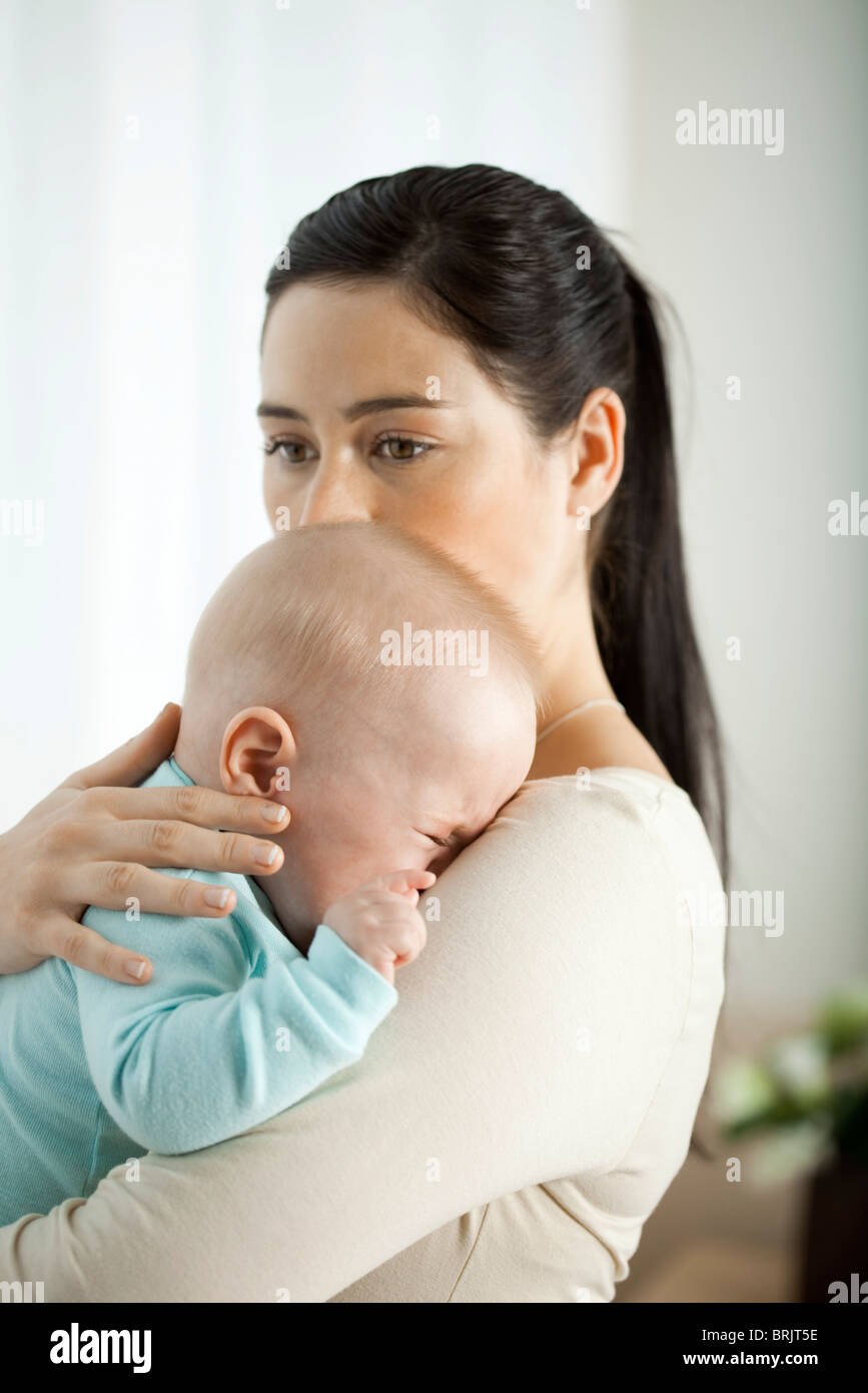 Mother comforting crying infant Stock Photo - Alamy