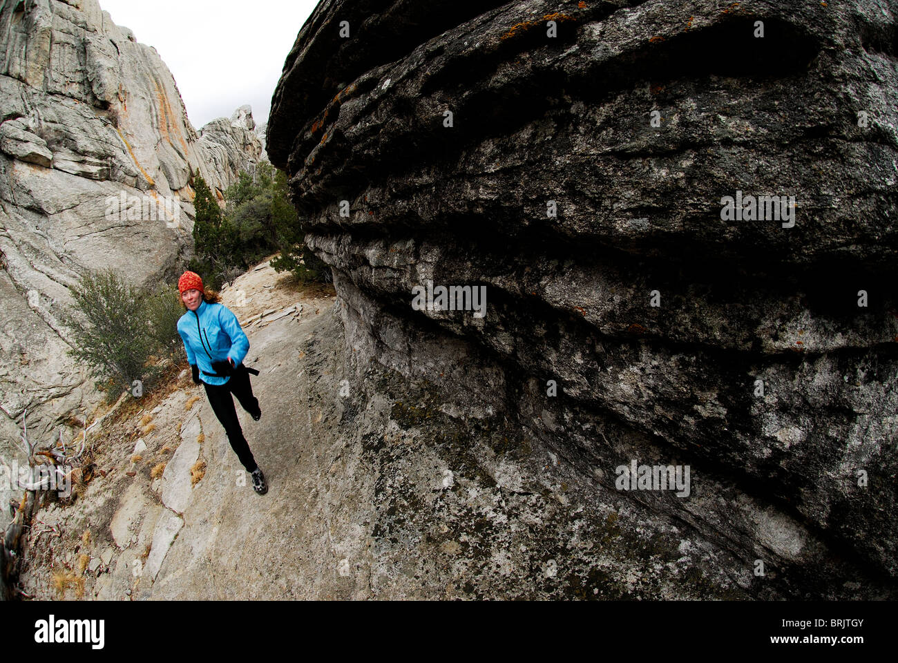 A woman trail running through a canyon Stock Photo - Alamy