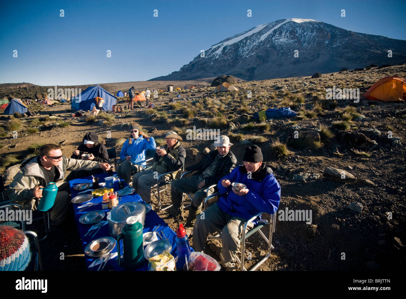 A team of hikers have a nice breakfast at sunrise about 1000 ft. below ...