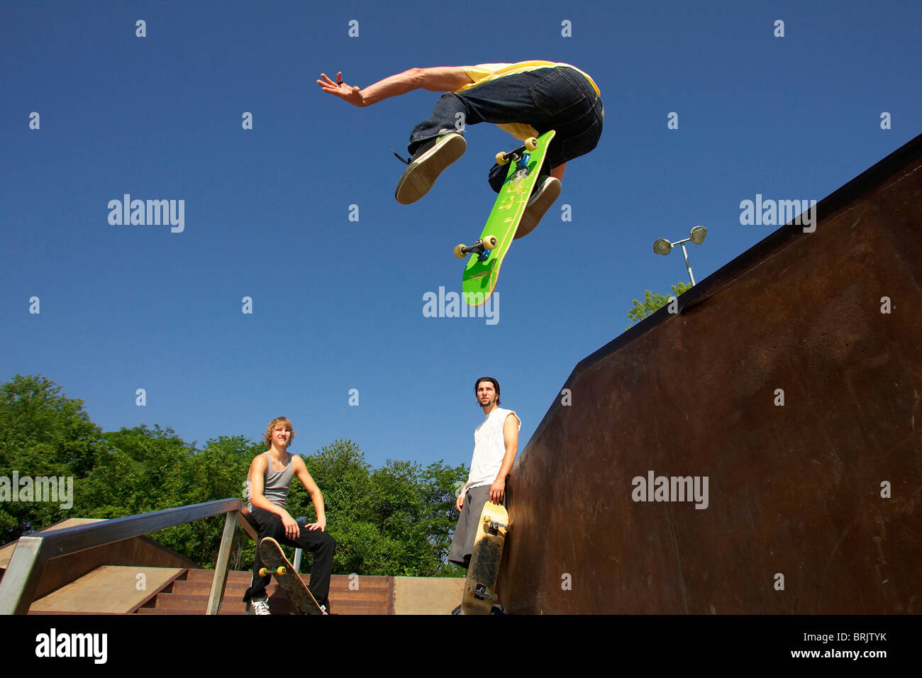 Three skateboarders doing tricks at a skate park Stock Photo - Alamy