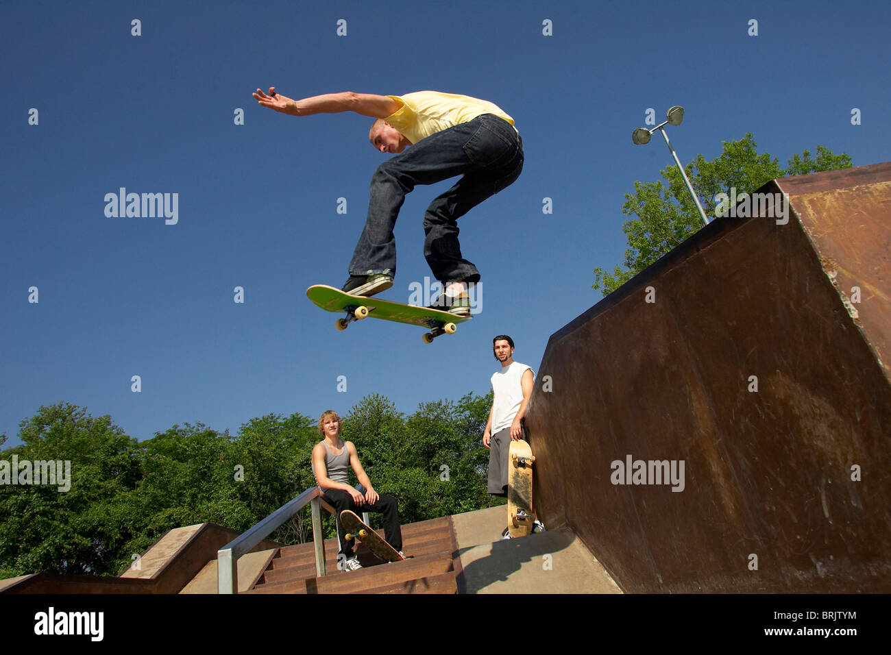 Three skateboarders doing tricks at a skate park Stock Photo - Alamy