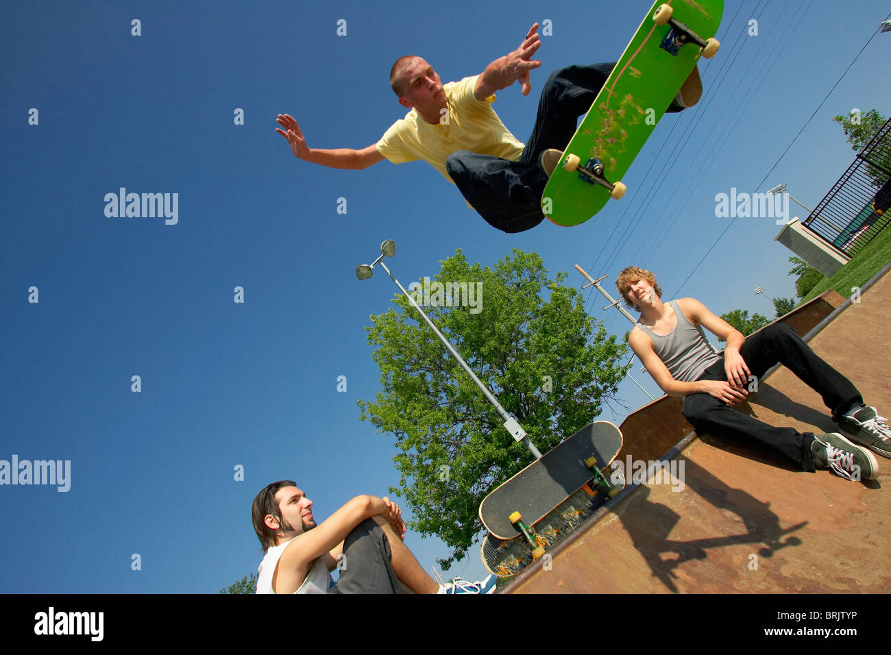 Three skateboarders doing tricks at a skate park Stock Photo - Alamy