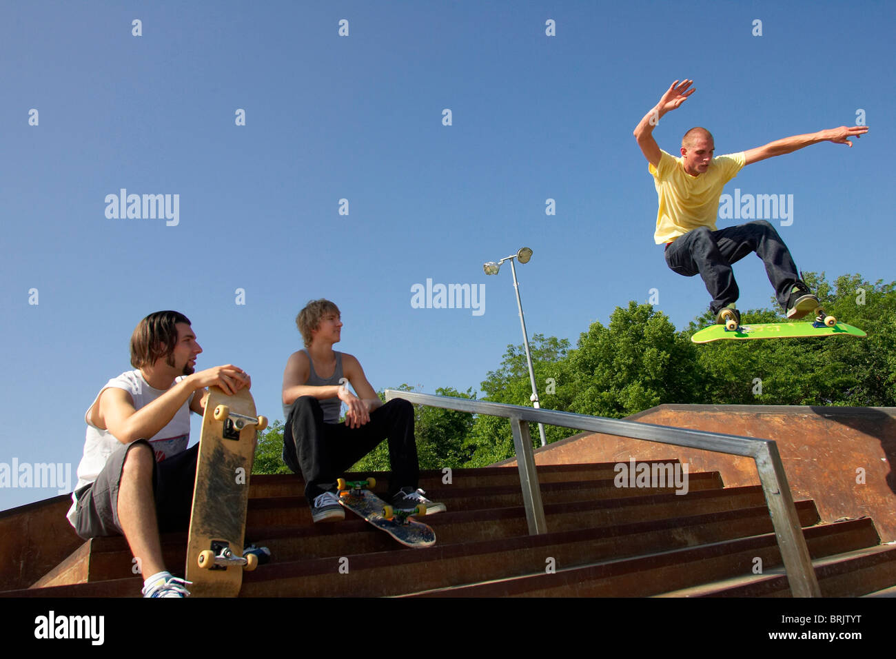 Three skateboarders doing tricks at a skate park Stock Photo - Alamy
