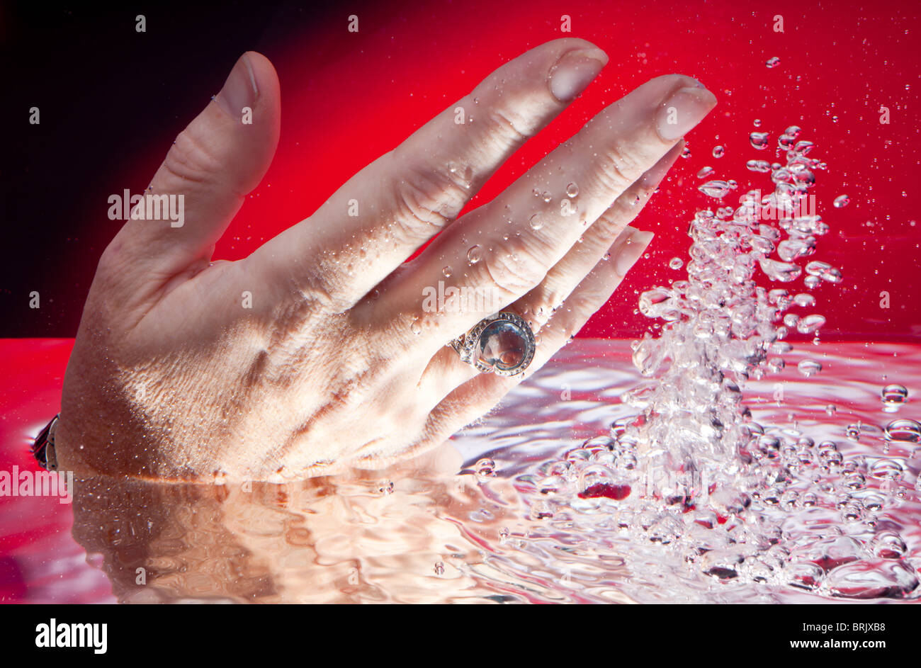 A hand rising out of water with bubbles Stock Photo - Alamy