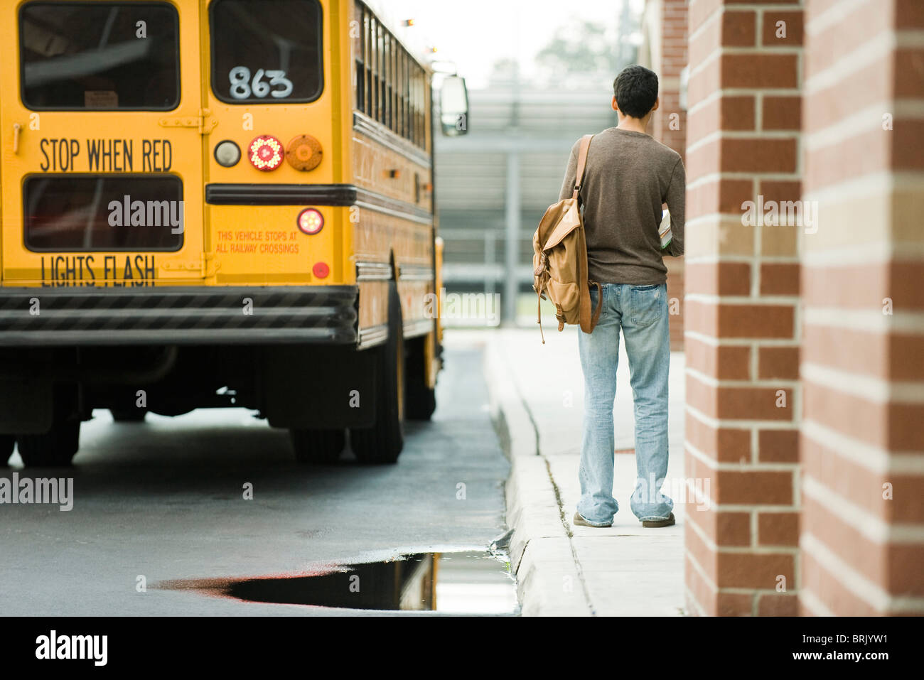 High school student waiting outside school for bus Stock Photo - Alamy