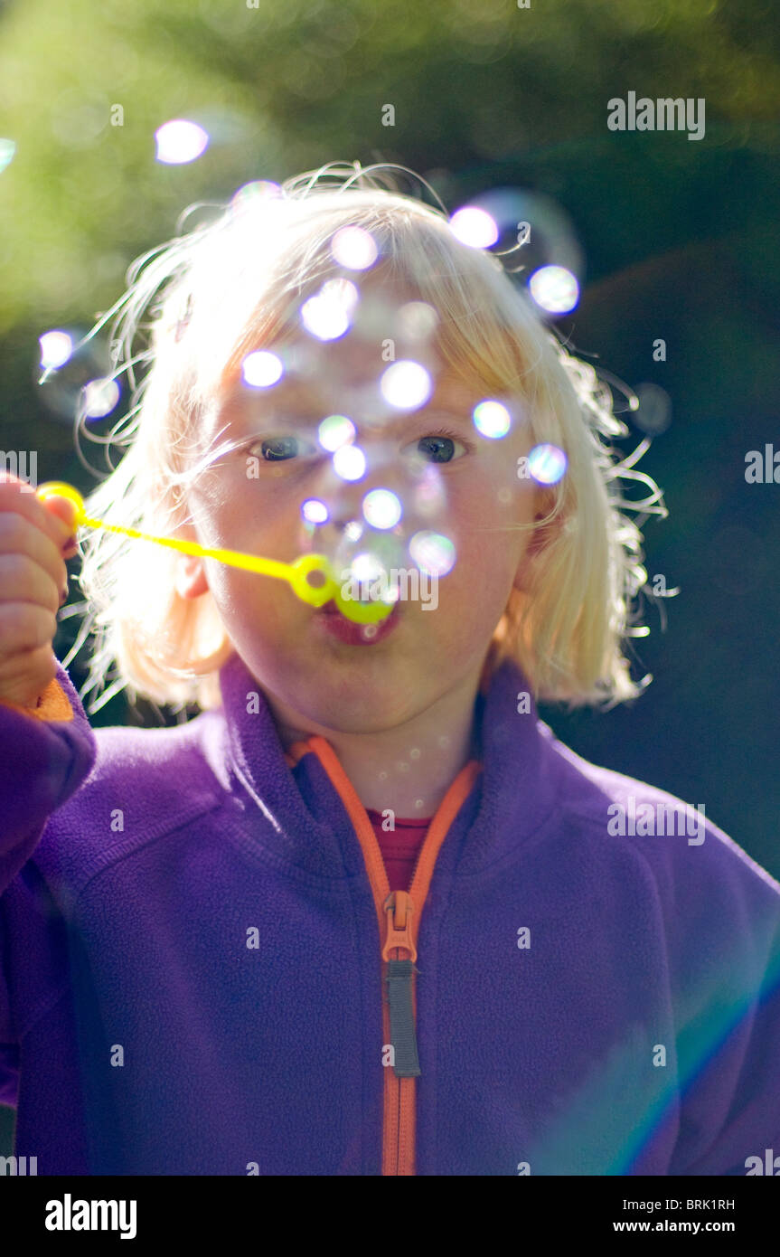 young child girl blowing bubbles in sunshine Stock Photo - Alamy