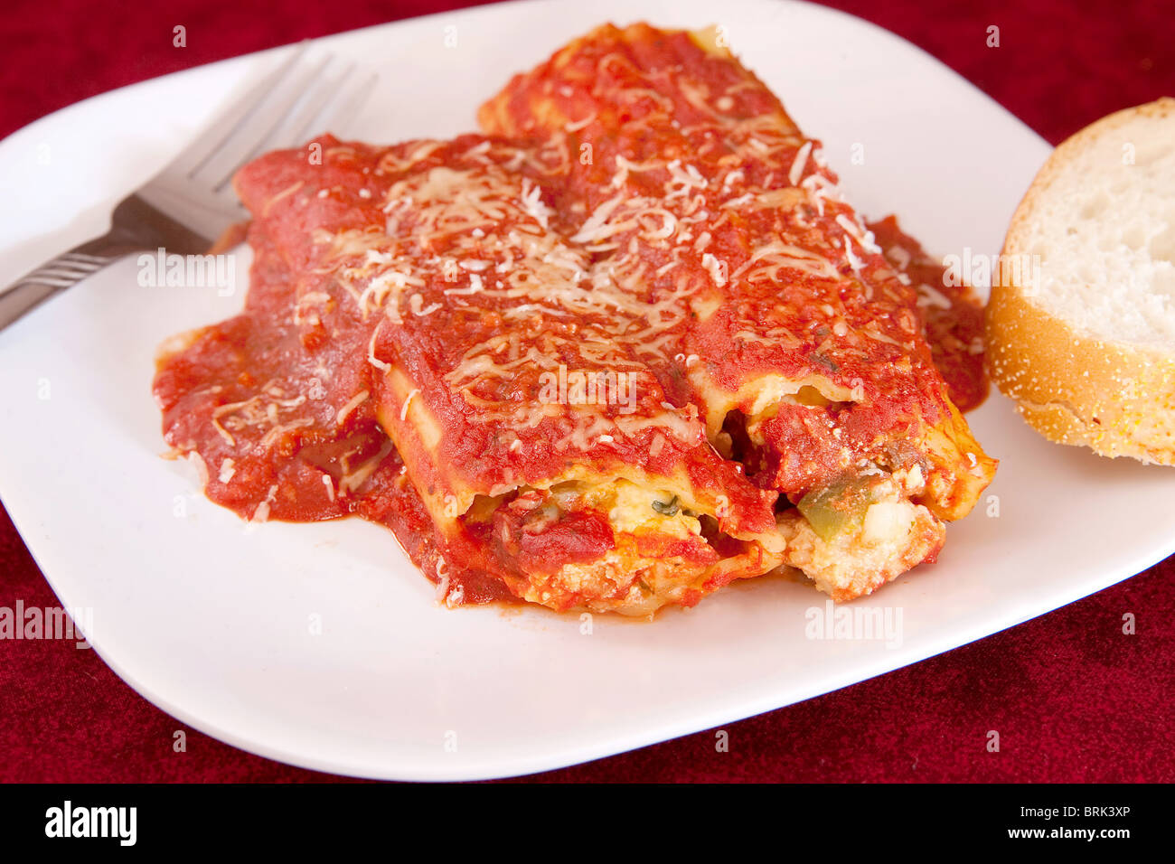 two tasty stuffed manicotti shells topped with pasta sauce and Italian ...