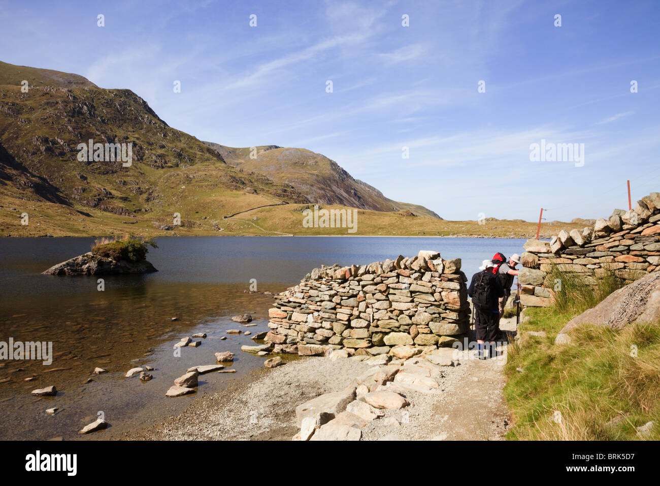 Cwm Idwal, Ogwen, North Wales, UK. Walkers going through gate in stone ...