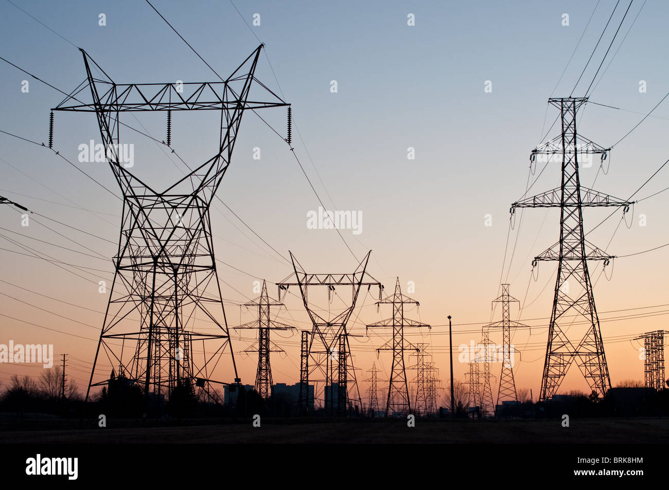 A long line of electrical transmission towers carrying high voltage ...