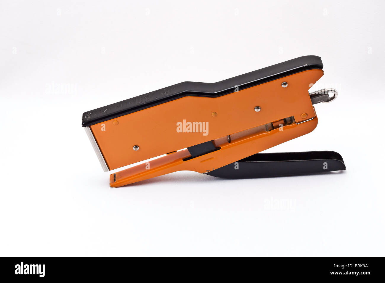 orange paper stapler standing on white background Stock Photo - Alamy