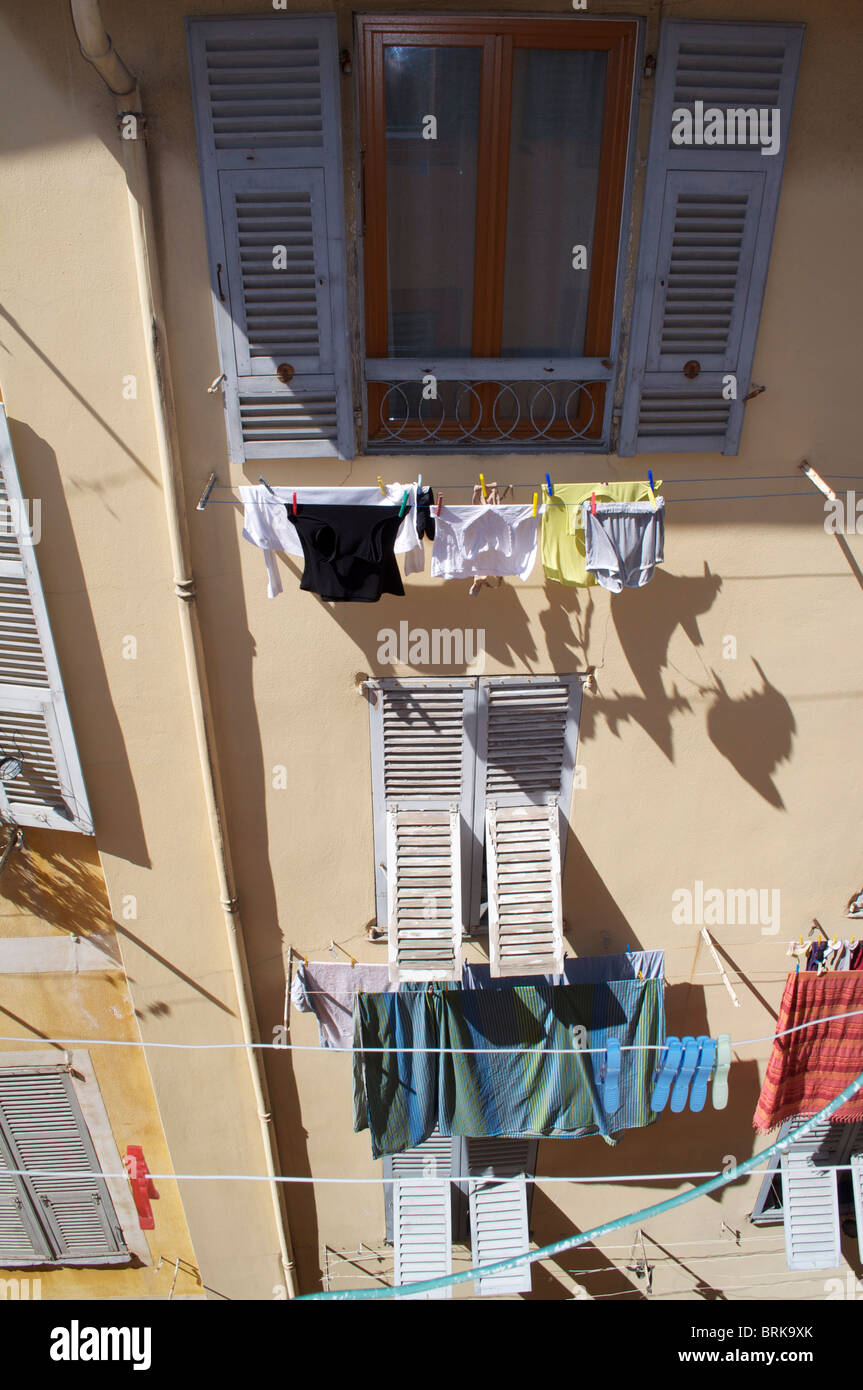 Washing hanging on outside of a building in south of France with wooden ...